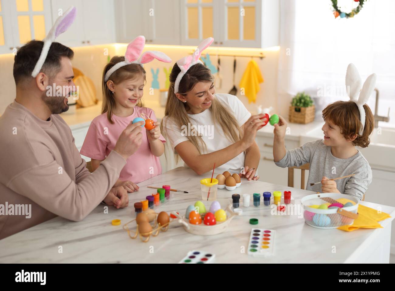 Easter celebration. Happy family with bunny ears having fun while ...