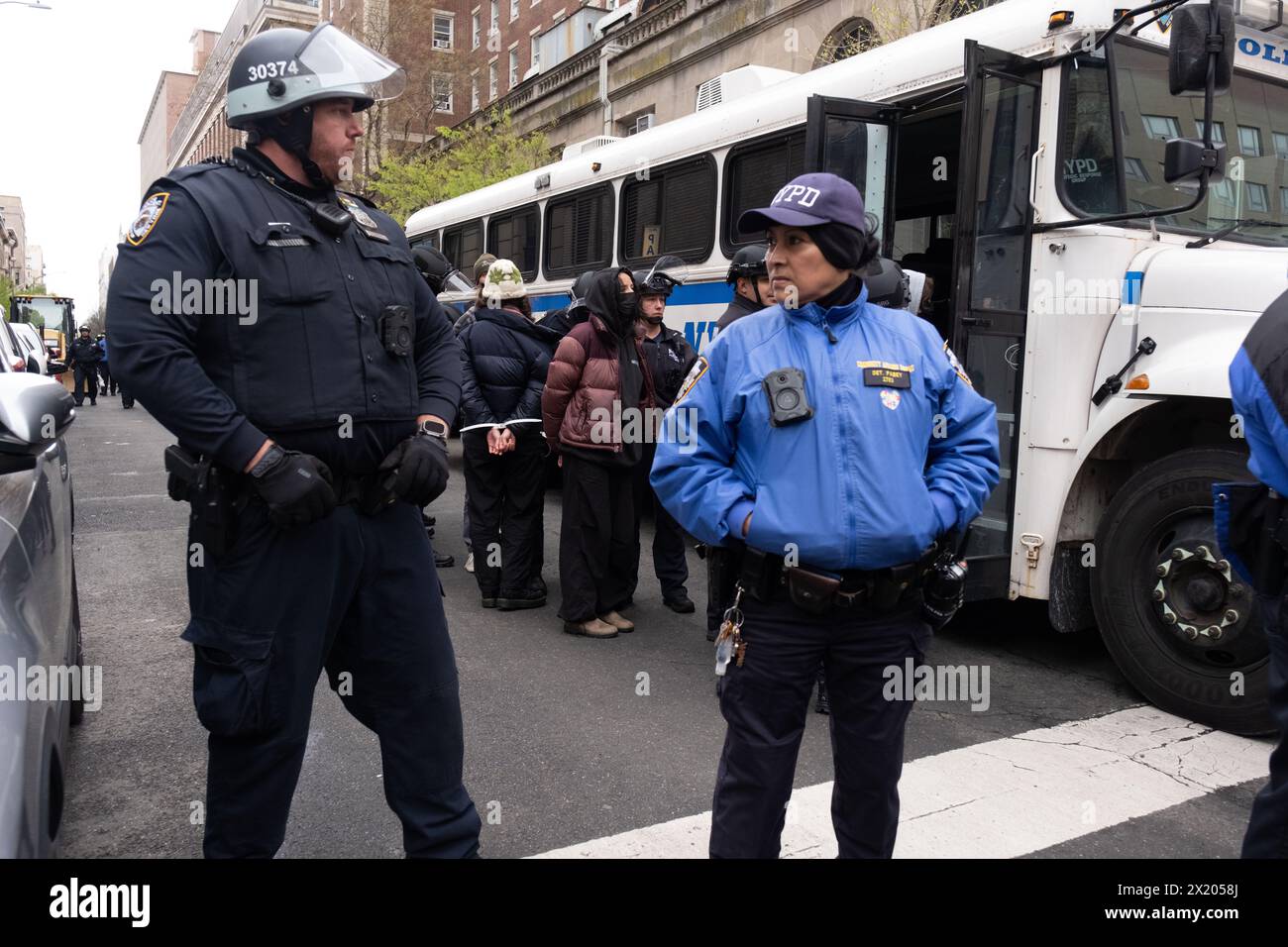 NYPD SRG officers lead students, wrists zip tied, on to the NYPD bus ...
