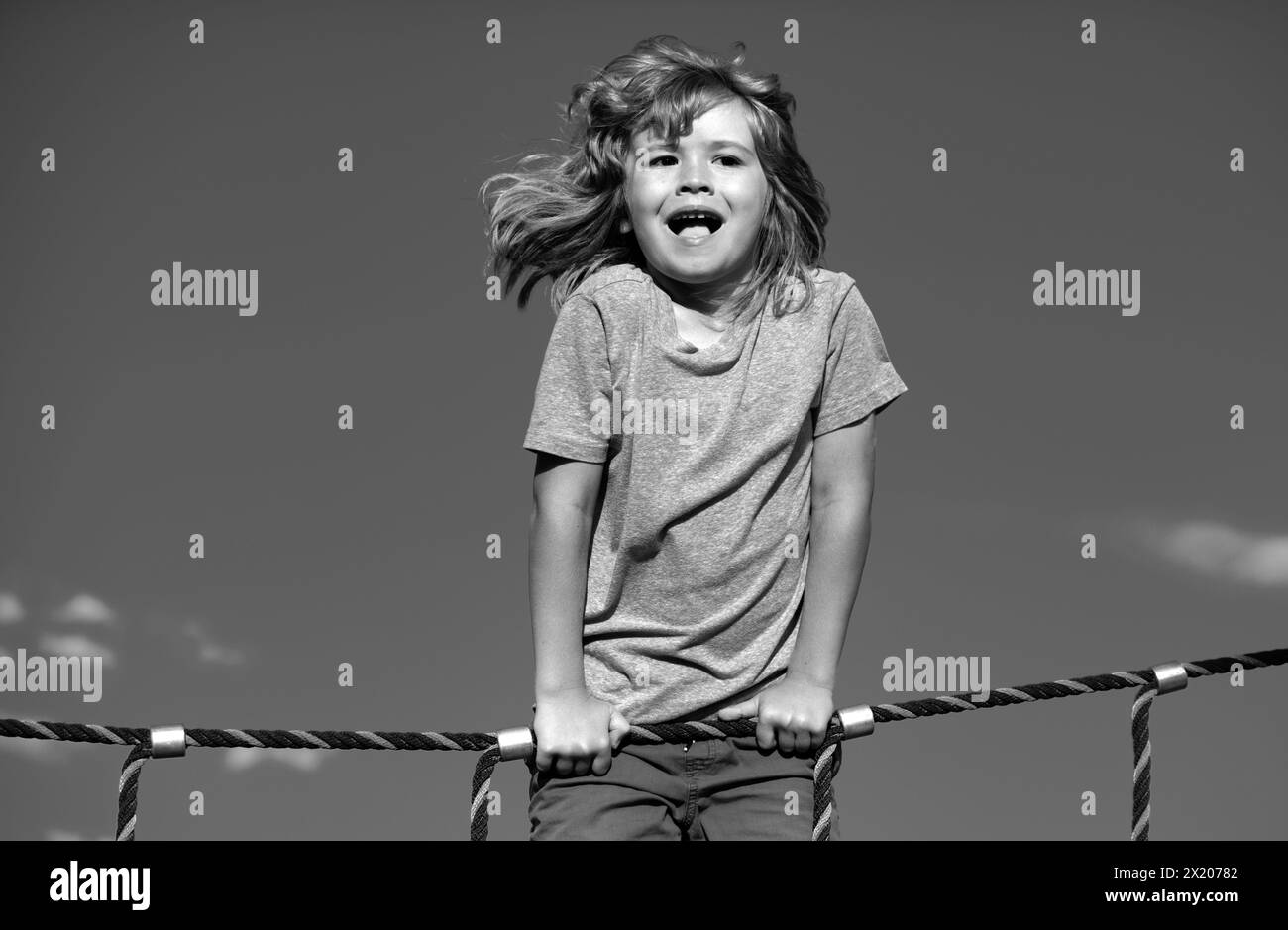Portrait of cute boy child doing rock climbing and monkey bars in the ...