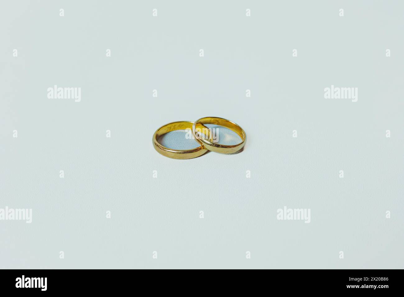 A close-up photo of two simple, elegant wedding rings resting side-by ...
