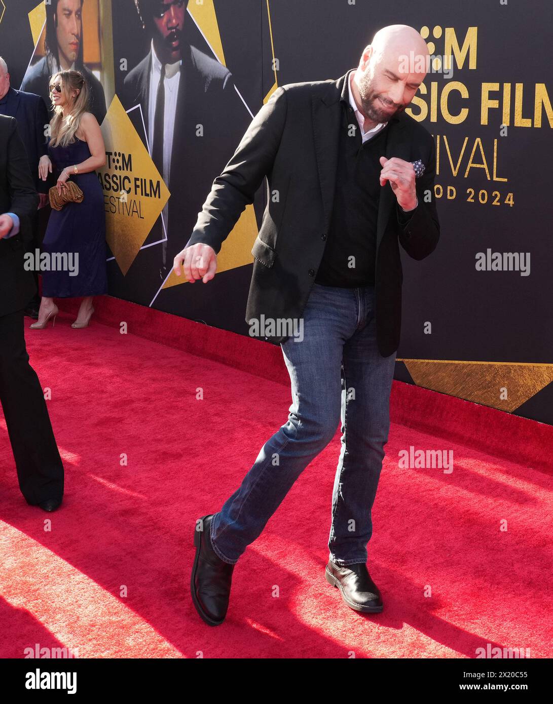John Travolta doing the twist dance on the red carpet at the 2024 TCM ...