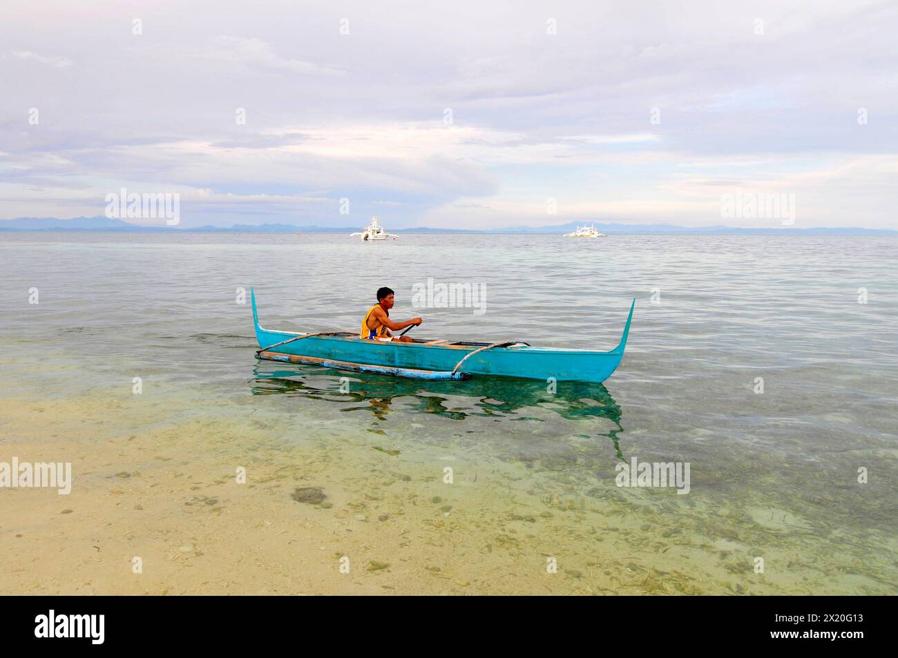A Filipino fisherman in a bangka boat in Malapascua, Central Visayas ...