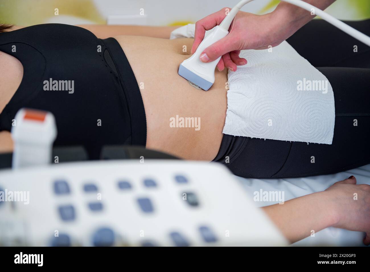 A healthcare professional conducts an ultrasound scan on a patients ...