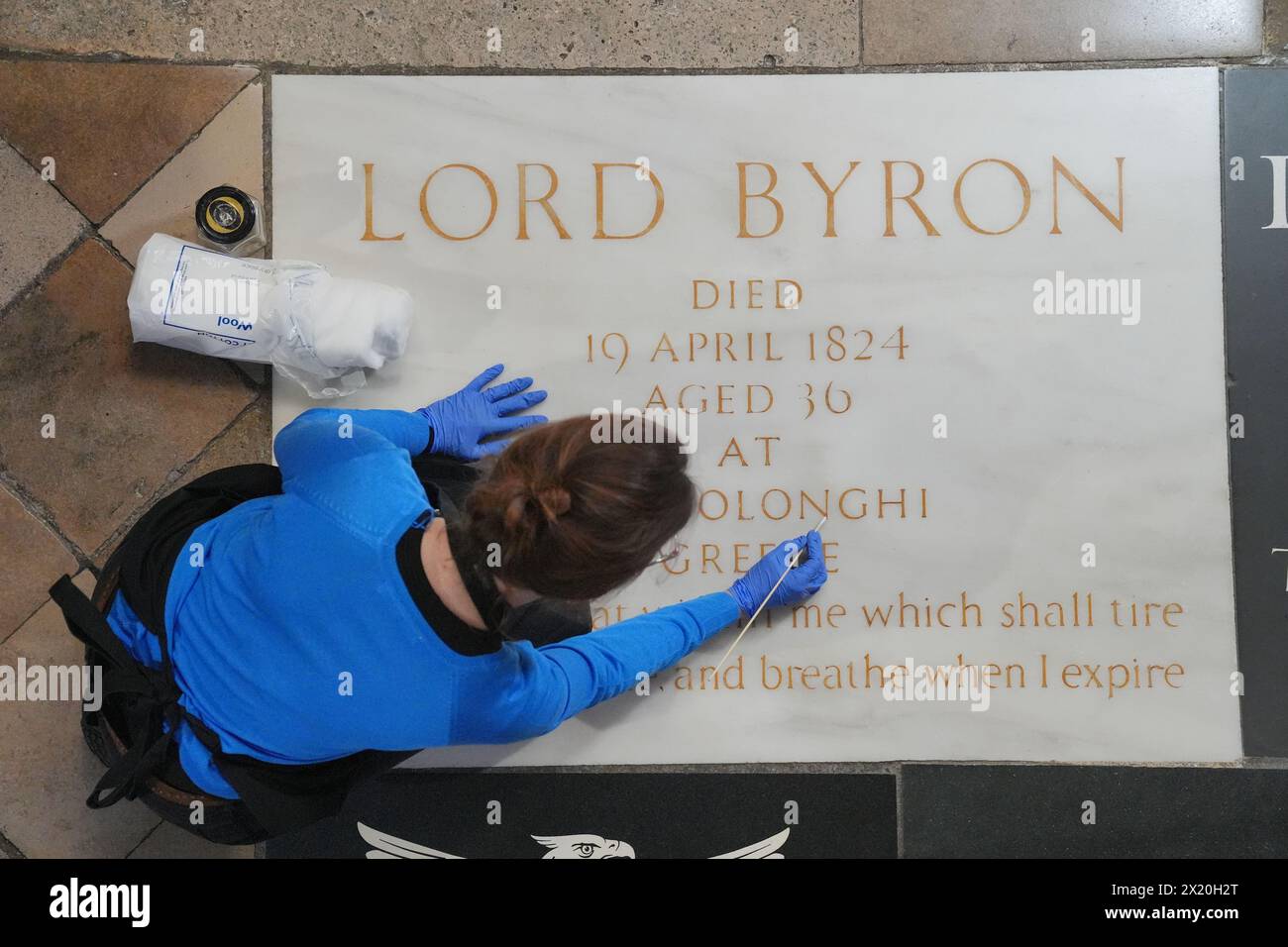 Conservator Lucy Ackland cleans Lord Byron's memorial stone in Poets' Corner at Westminster ...