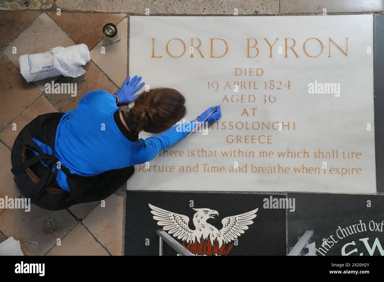 Conservator Lucy Ackland cleans Lord Byron's memorial stone in Poets' Corner at Westminster ...