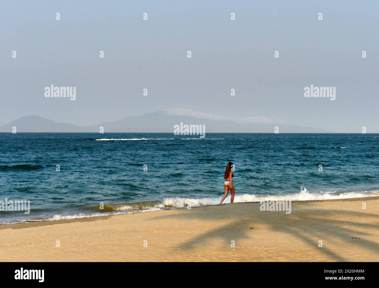 A tourist walking on the beautiful Cua Dai beach in Hoi An, Vietnam ...