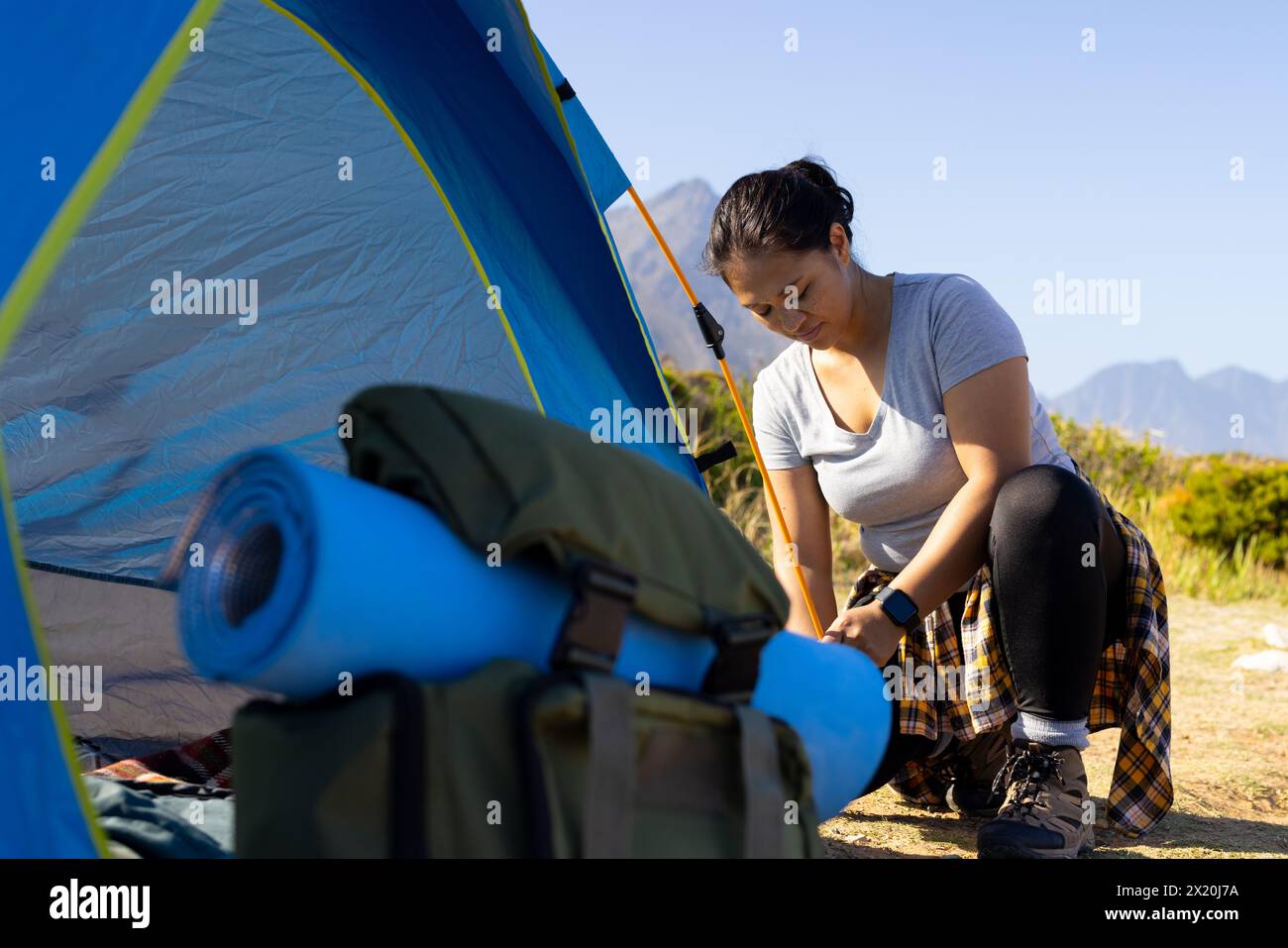 Biracial female hiker wearing casual clothes setting up a tent Stock ...