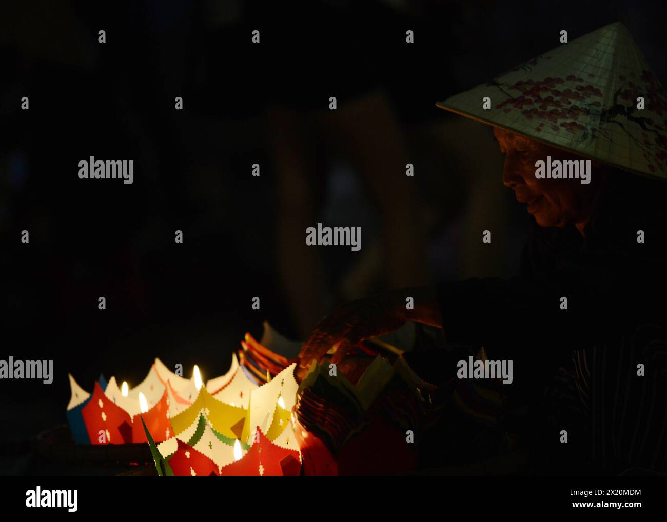 An old Vietnamese woman selling floating candle lanterns for use on the ...