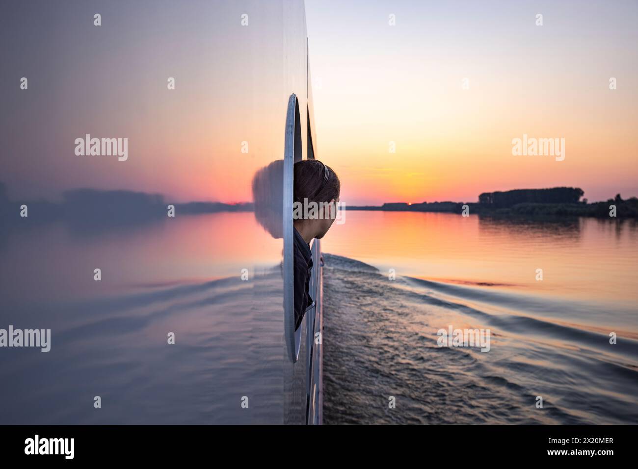 Woman looking through window opening on board river cruise ship Maxima ...