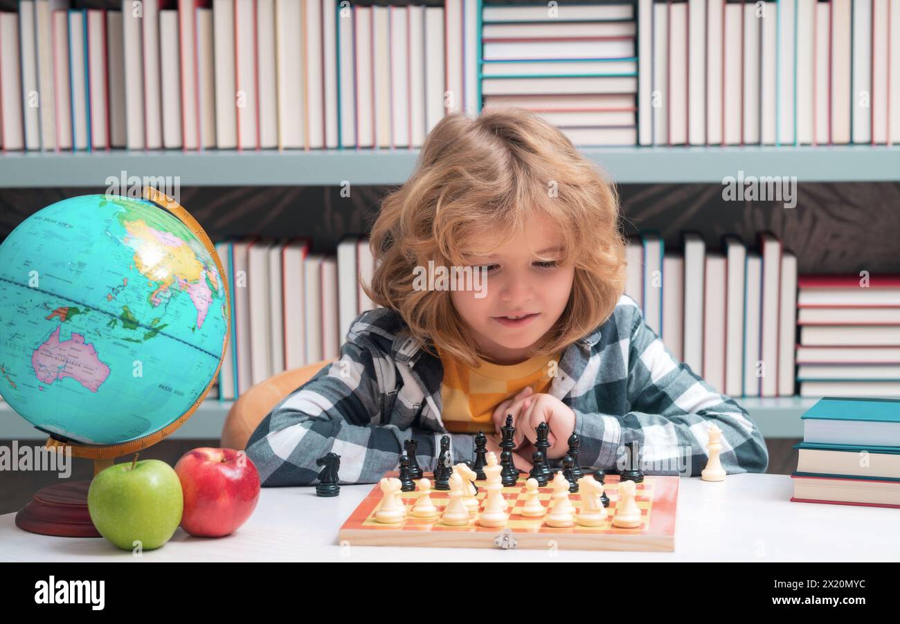 Child Play chess. Clever concentrated and thinking kid playing chess ...