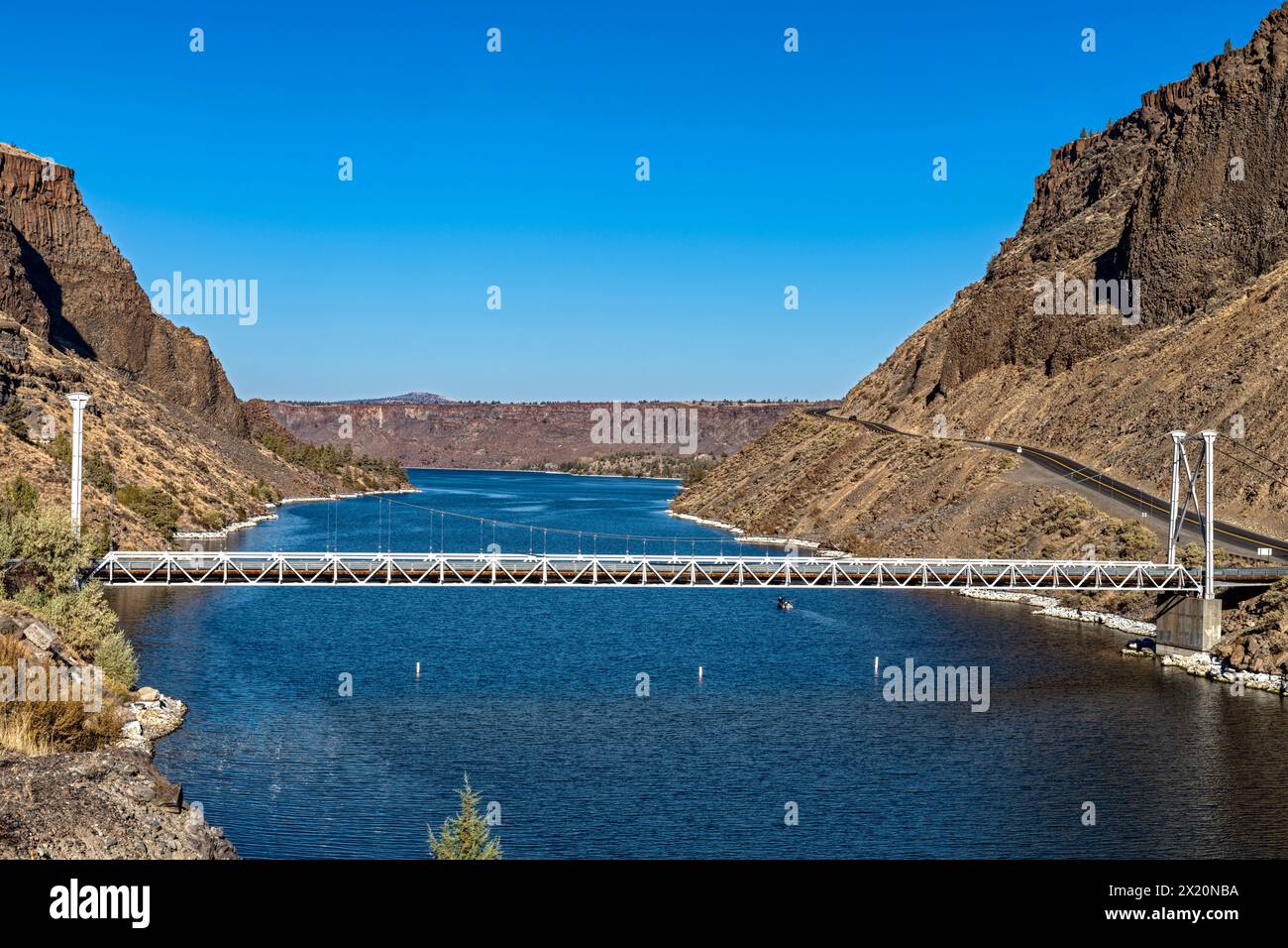 The one-lane bridge spans the Deschutes River flowing between steep ...