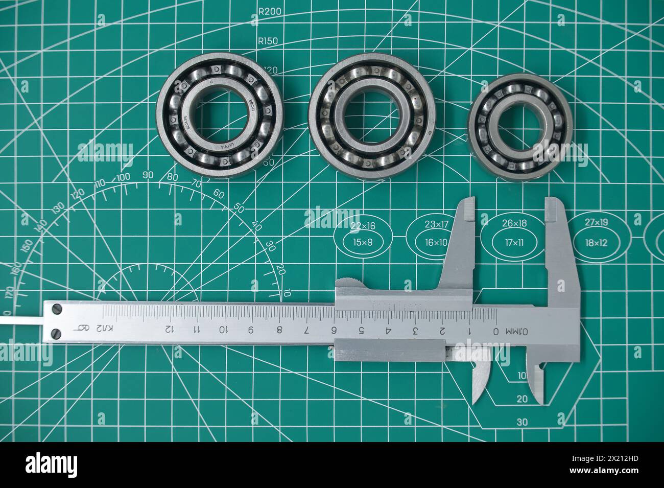 Measure caliper and roller bearings on green cutting mat with free copy ...