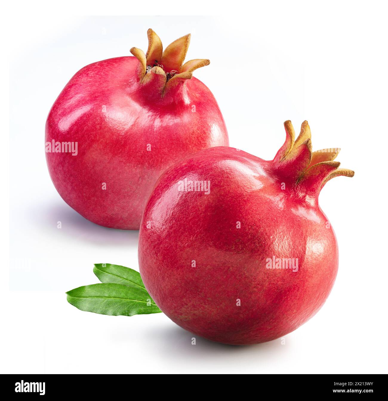 Two pomegranates with leafs isolated white background Stock Photo - Alamy