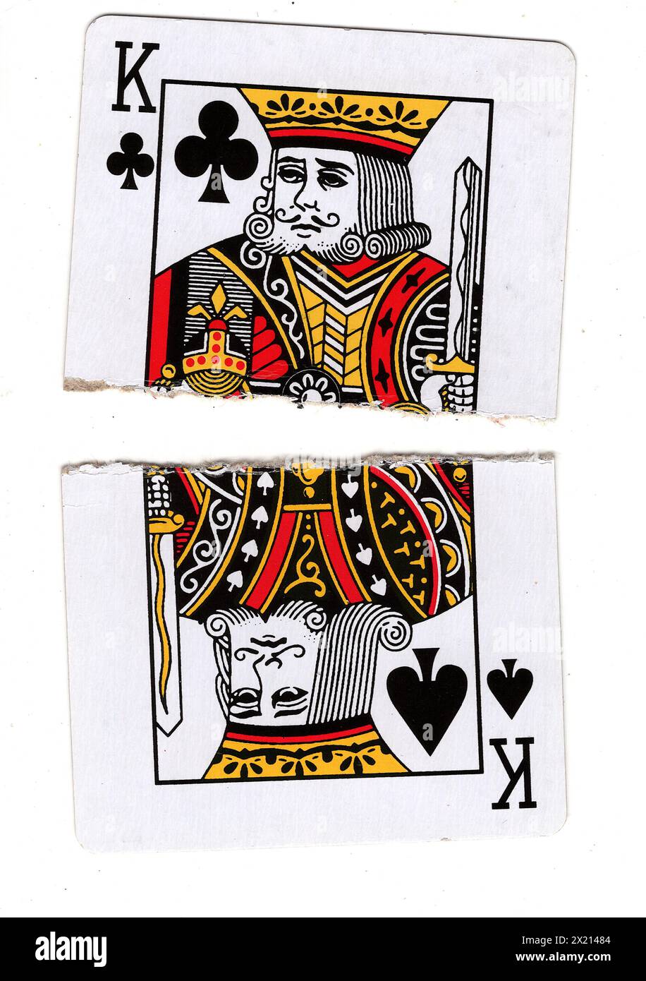 A king of clubs and king of spades playing cards torn in half on a ...