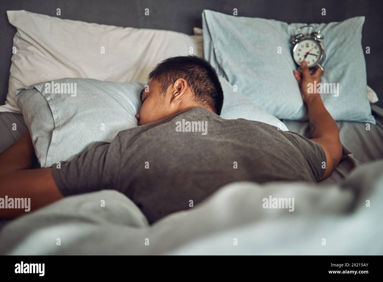 Man, sleeping and bed with alarm clock or tired insomnia for bad time ...