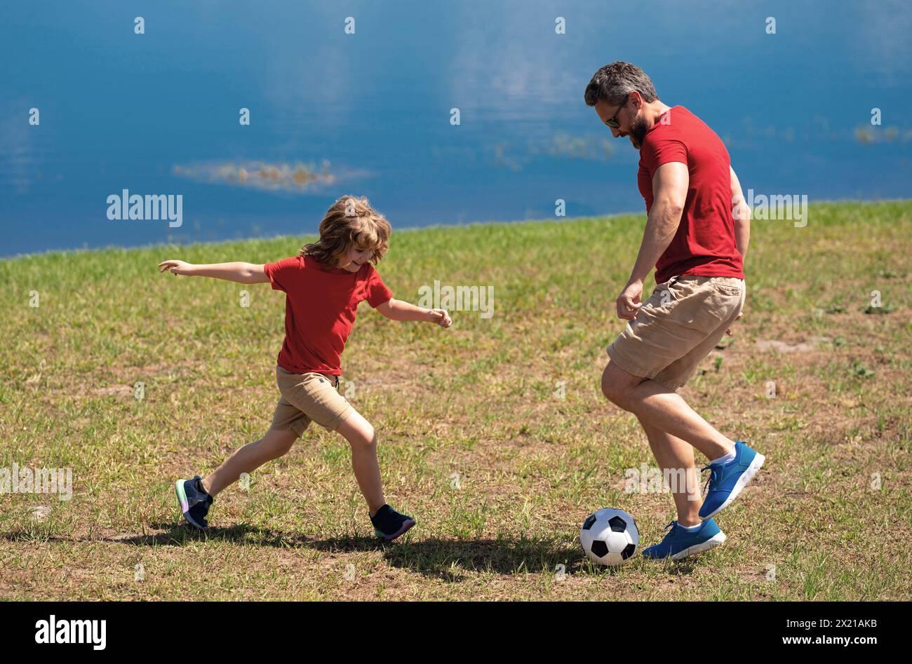 Dad with his little cute son are having fun and playing football on ...