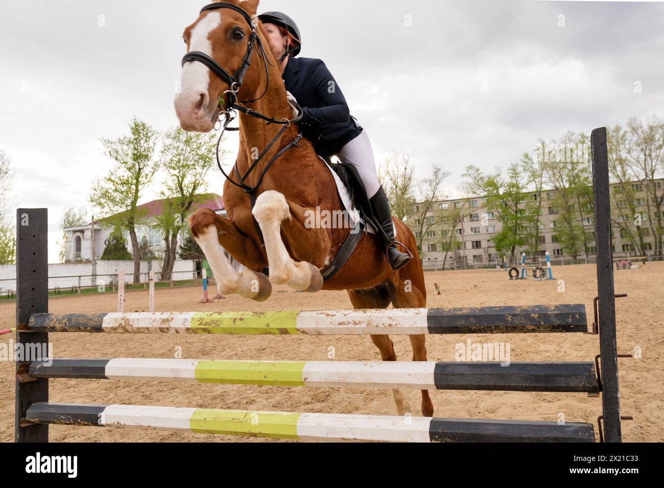 Equestrian event, rider and horse mid-obstacle course. Female jockey in ...