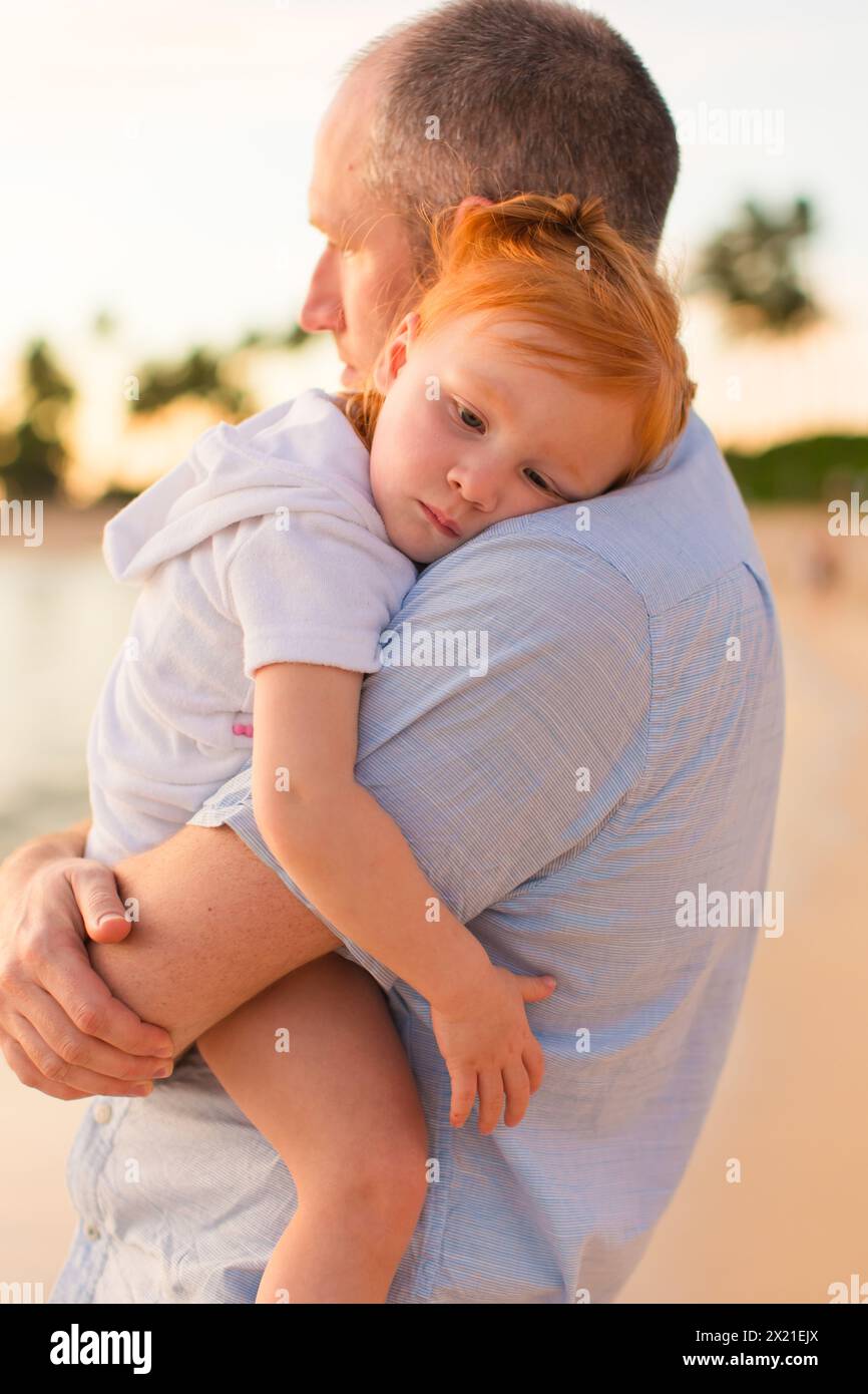 Tired redheaded girl laying on fathers shoulder Stock Photo - Alamy
