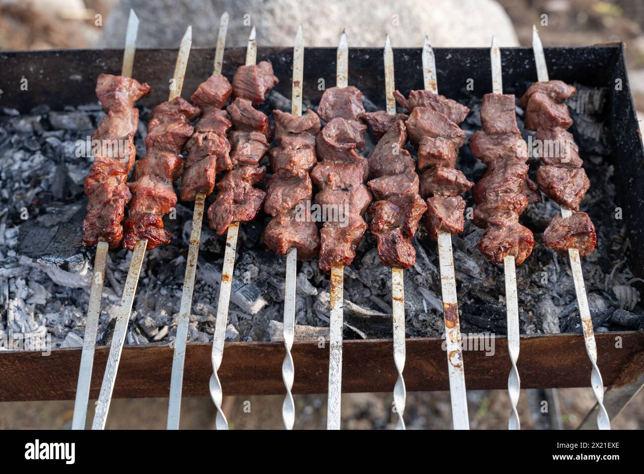 A skewer of meat is being cooked on a grill Stock Photo - Alamy