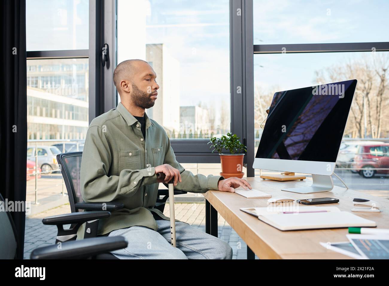 disabled african american man with myasthenia gravis sits at a desk ...