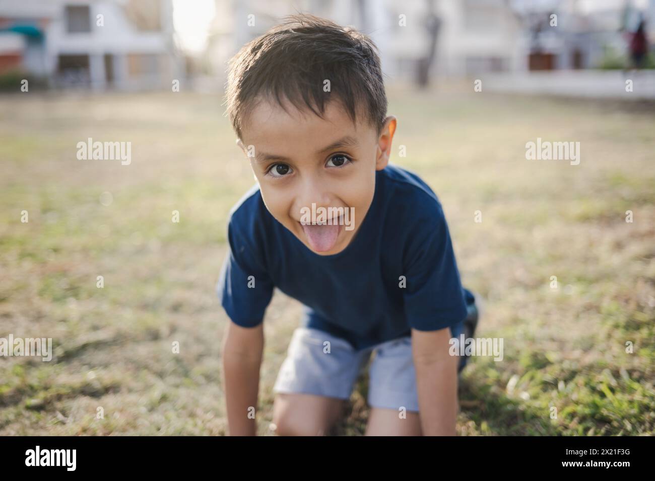 Joyful kid having fun sticking out tongue in the park at sunset Stock ...