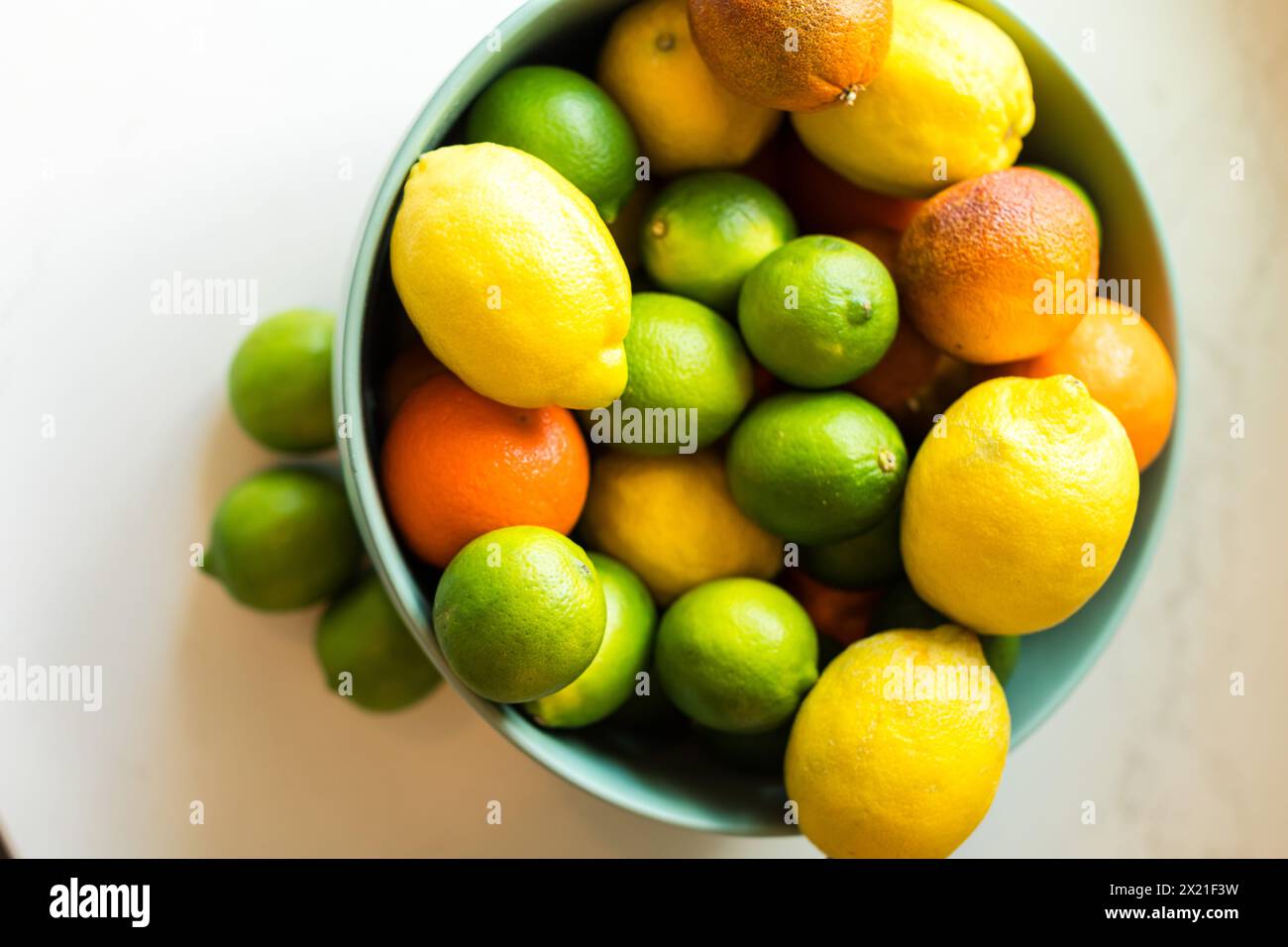 Assorted citrus fruits in a green bowl Stock Photo - Alamy