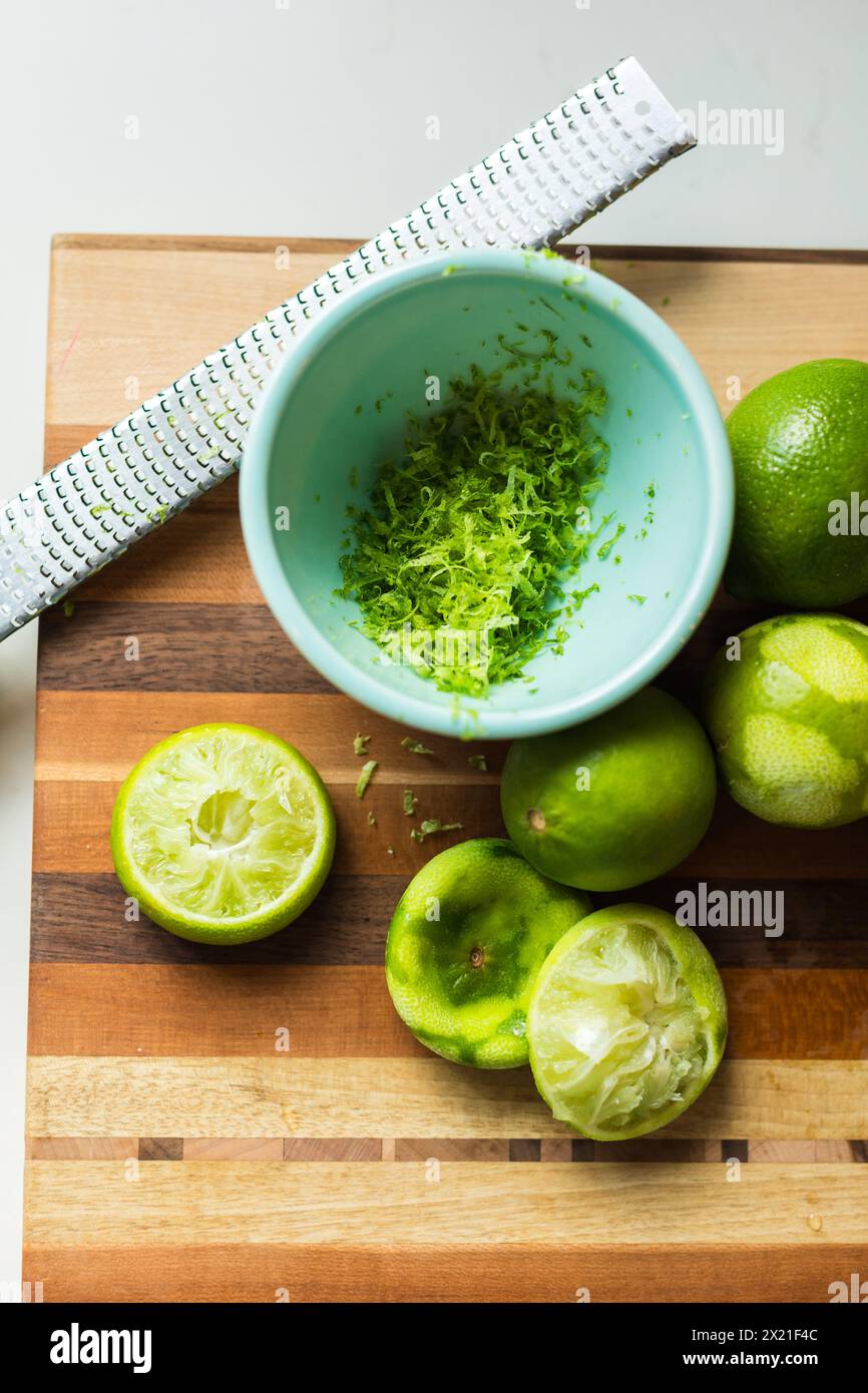 Zested and halved limes on a striped cutting board Stock Photo - Alamy