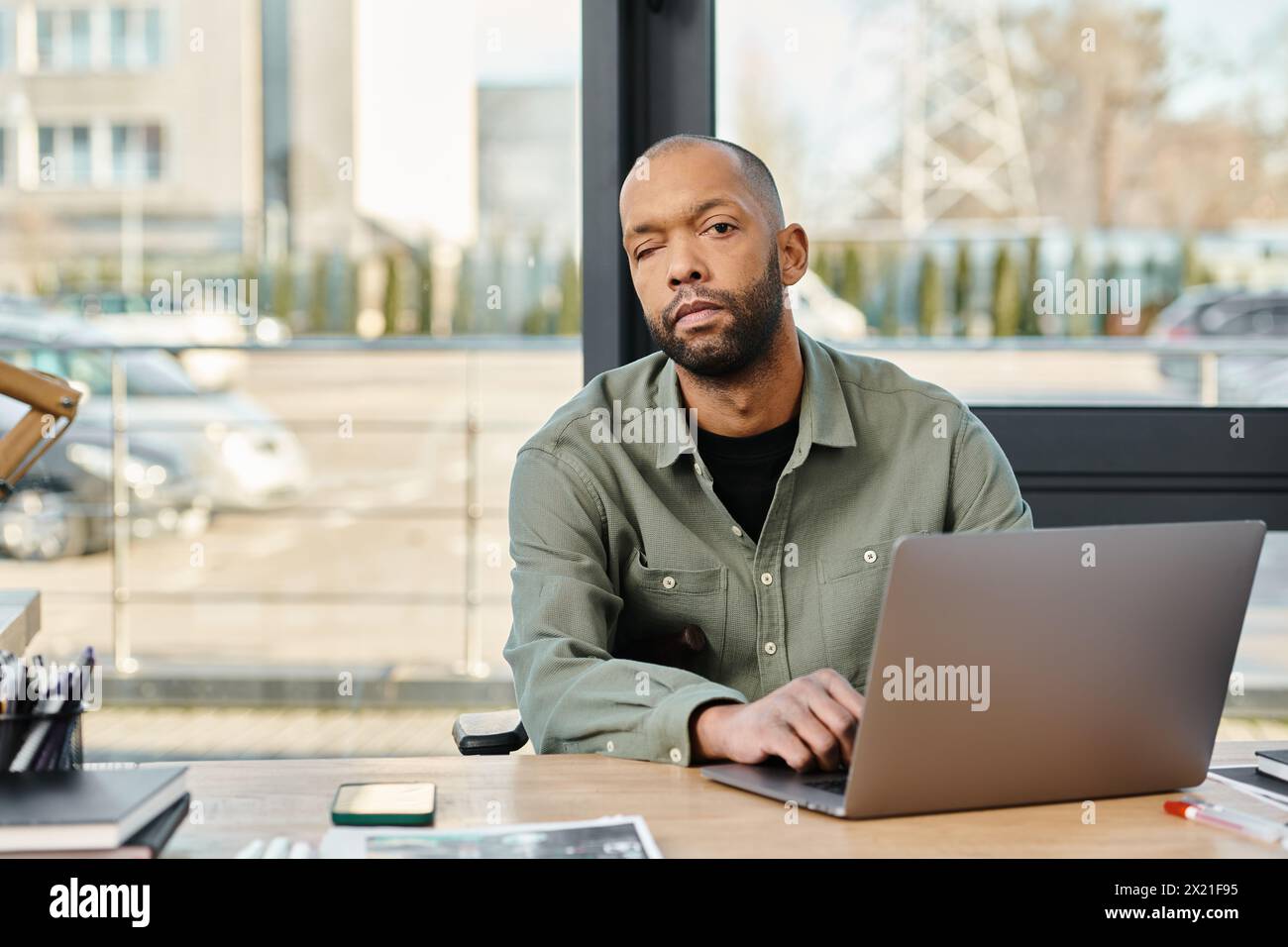 disabled man immersed in work, sitting in front of a laptop computer in ...