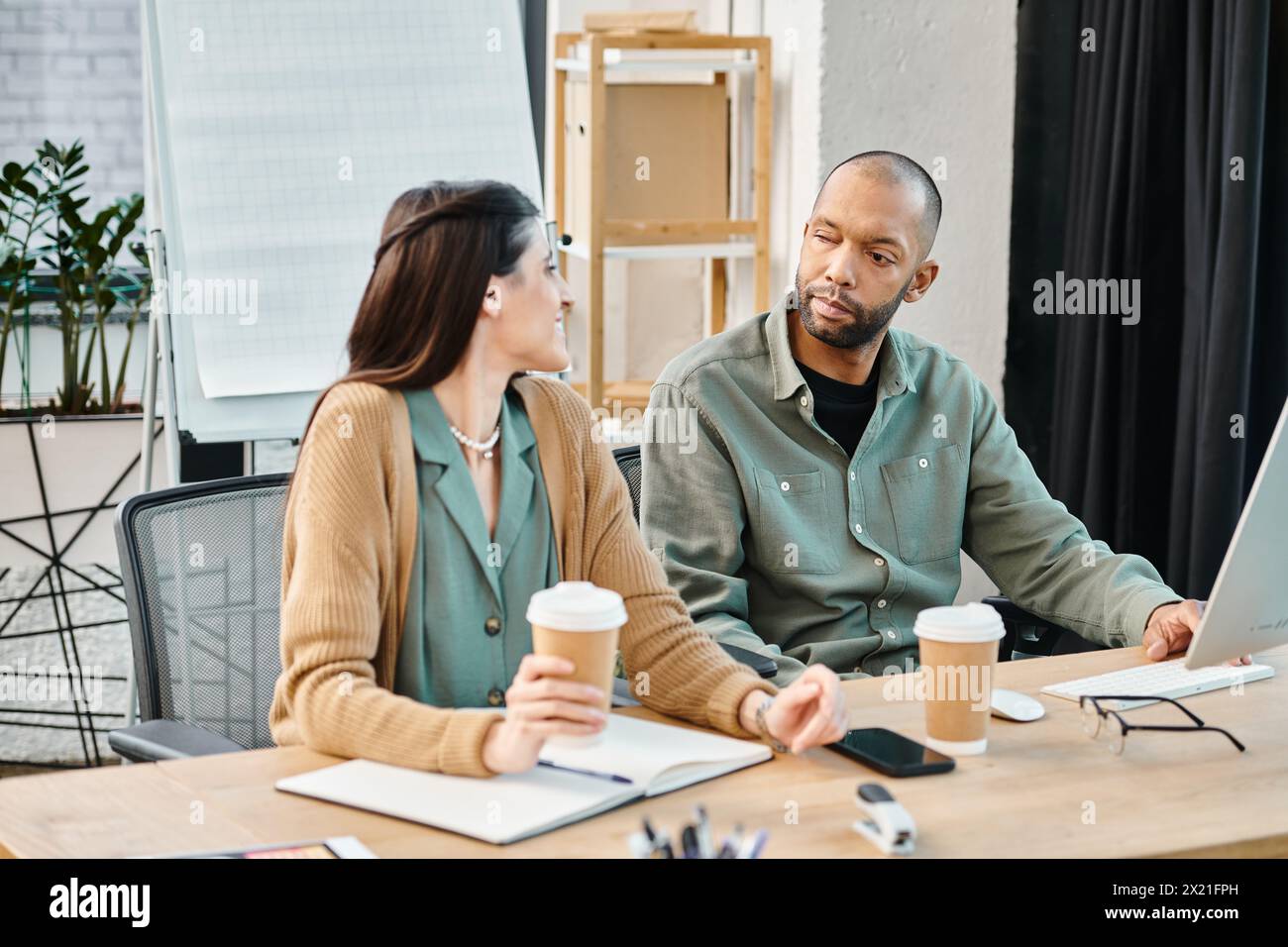 disabled man and woman sit at a table, engrossed in their work on a ...