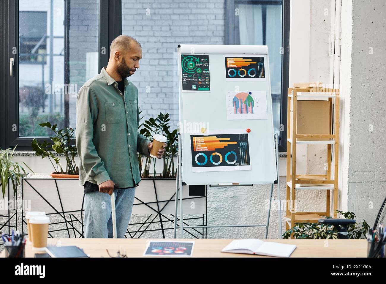 A man standing in front of a whiteboard, presenting ideas to a team in ...