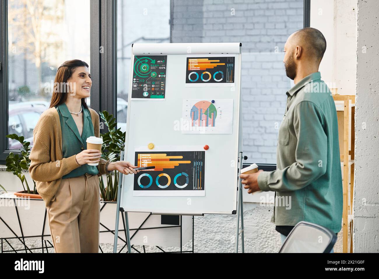 A man and a woman are presenting in front of a whiteboard in a ...