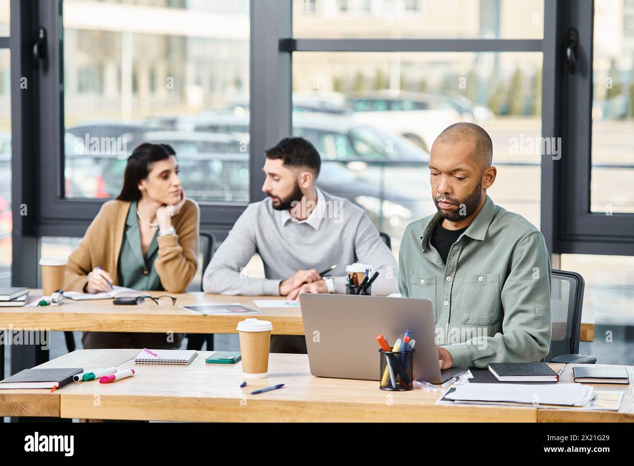 Three individuals engage in a productive meeting, huddled around a ...