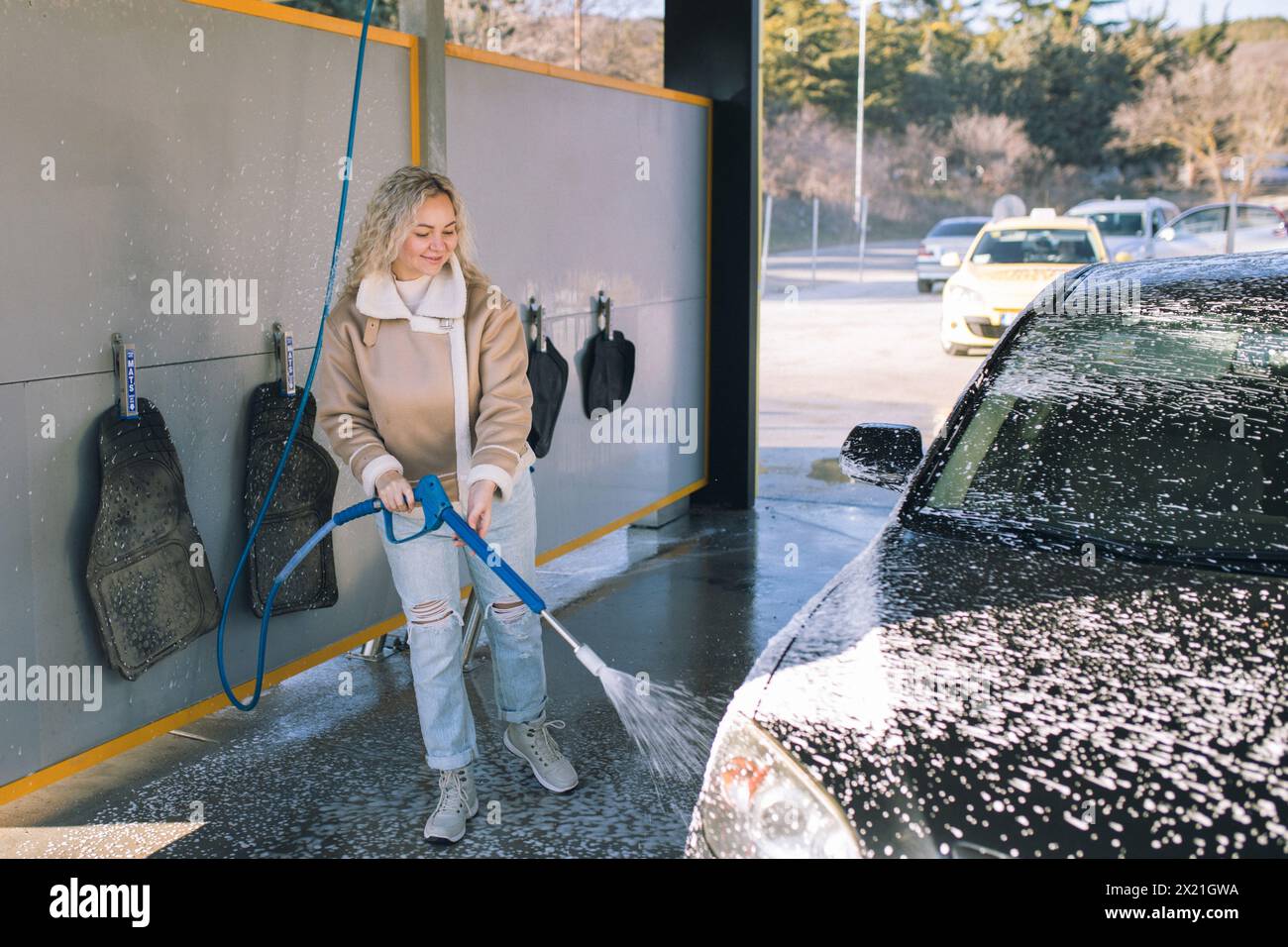 Beautiful young women washes the car at the self-service car wash Stock ...