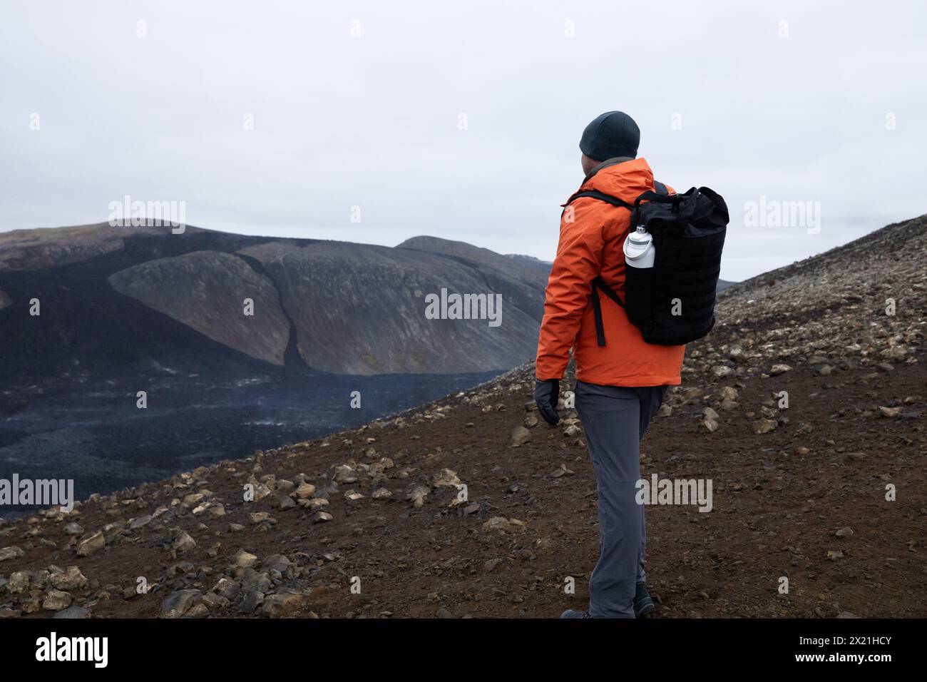Hiker gazing over a desolate volcanic mountain vista Stock Photo - Alamy