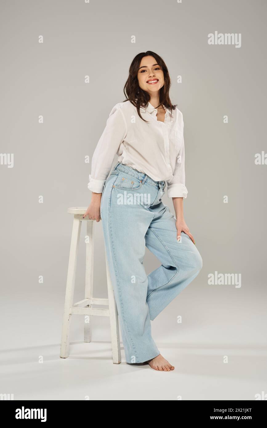 A beautiful plus size woman poses confidently in a white shirt and ...