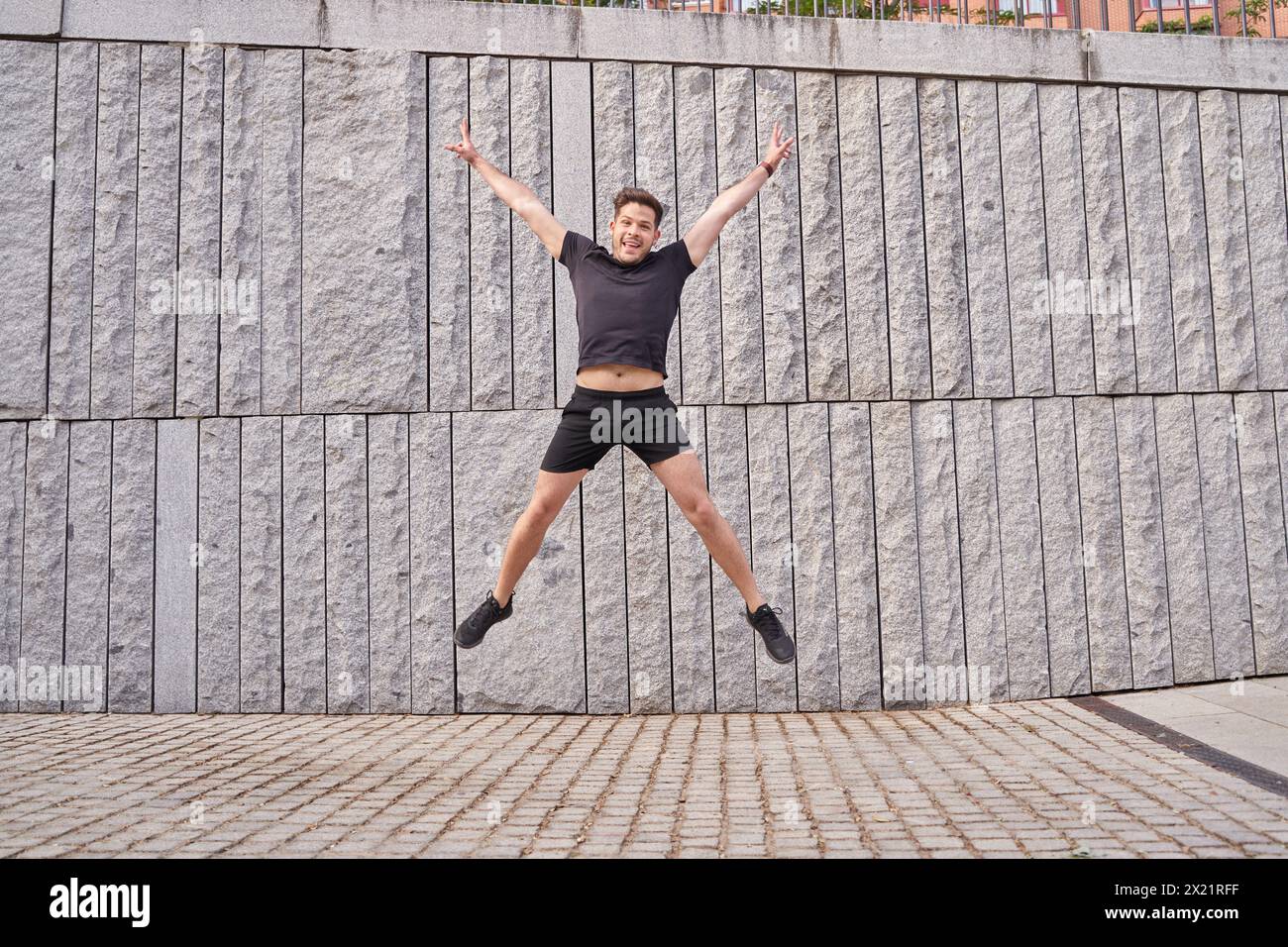 young enthusiastic latin man jumping with arms and legs wide open Stock ...