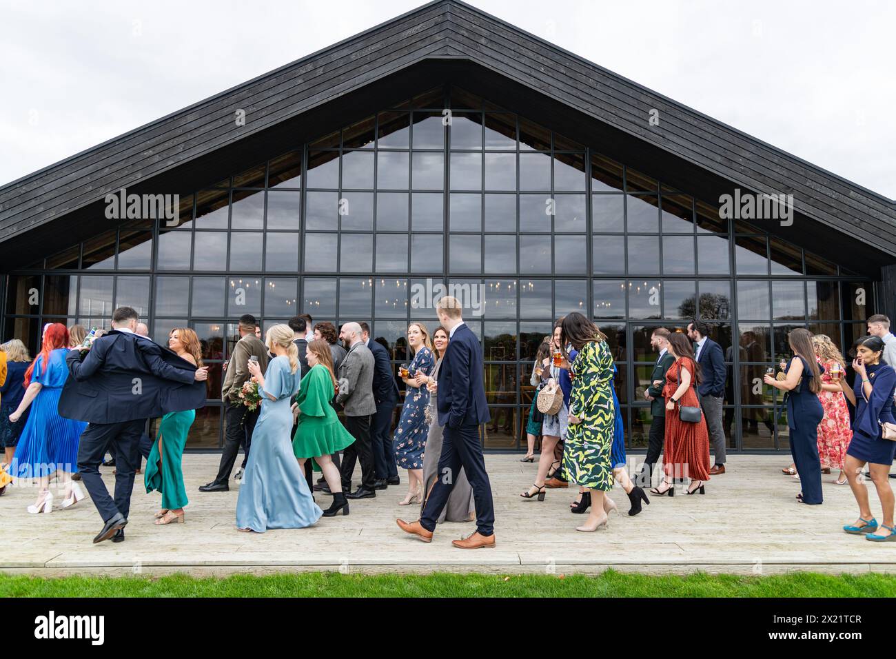 Wedding guests friends and family walking outside to a reception ...
