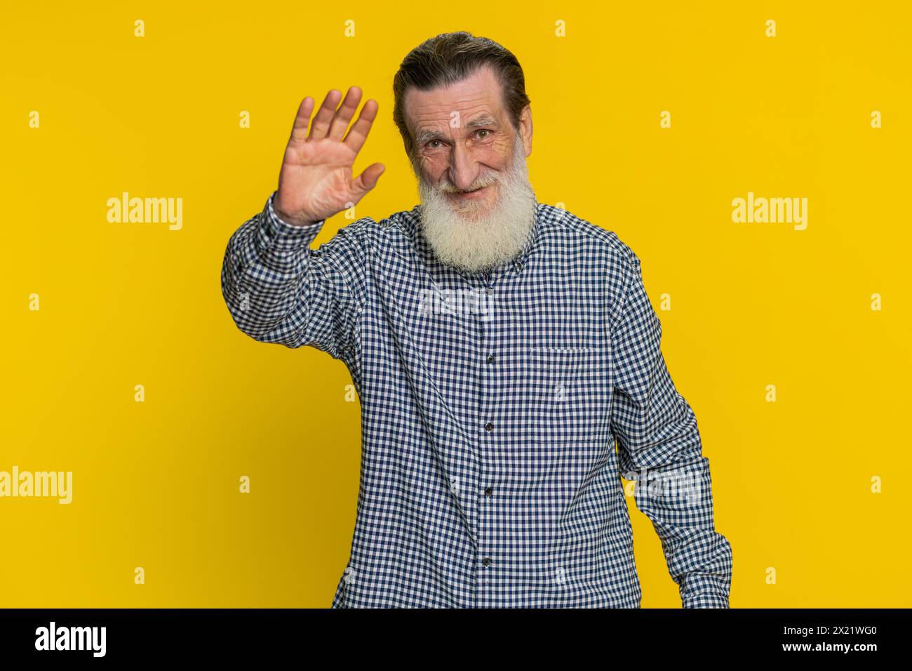 Old senior man smiling friendly at camera, waving hands gesturing hello ...