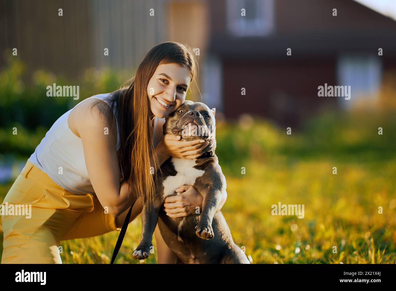 Young woman raised muzzle of American Bully to take joint portrait with ...