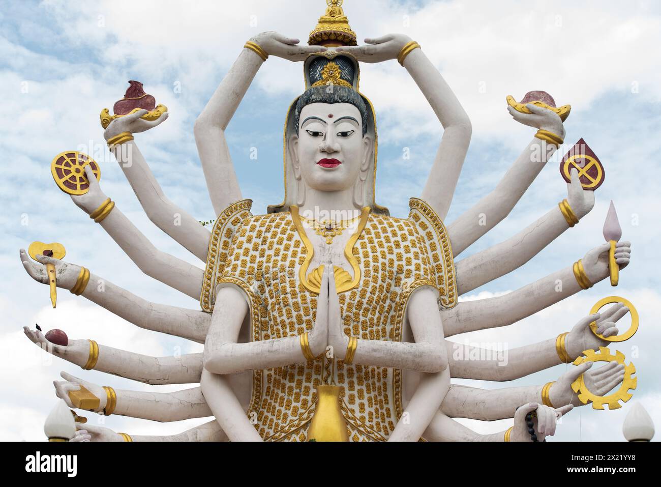 A striking statue with multiple arms and serene expression stands ...