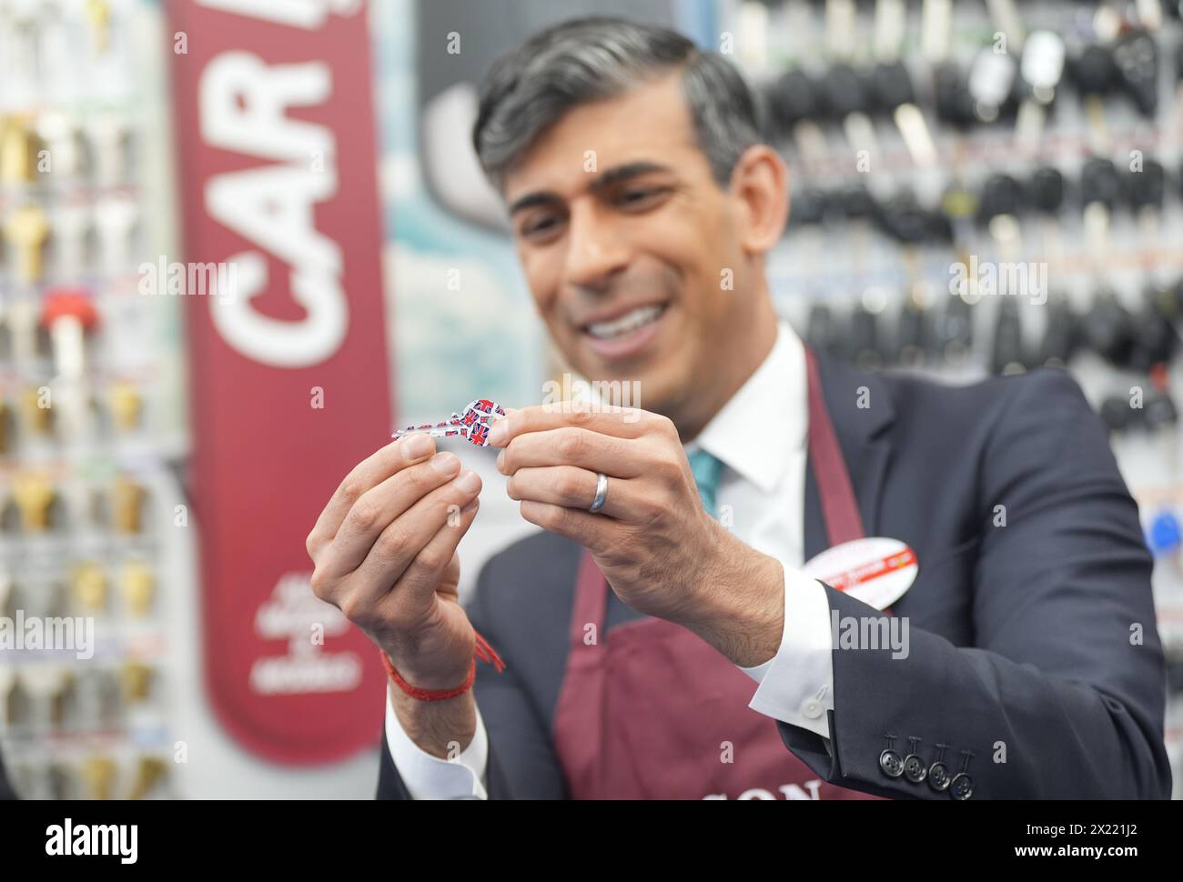 Prime Minister Rishi Sunak looks at a key after operating a cylinder ...