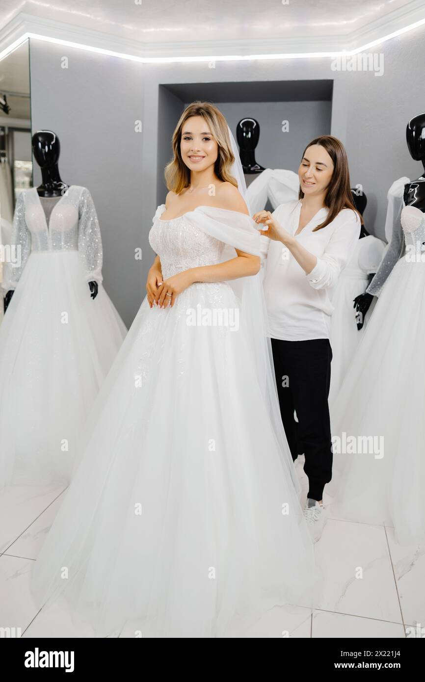 The bride-to-be chooses a dress for the wedding. A dressmaker's ...