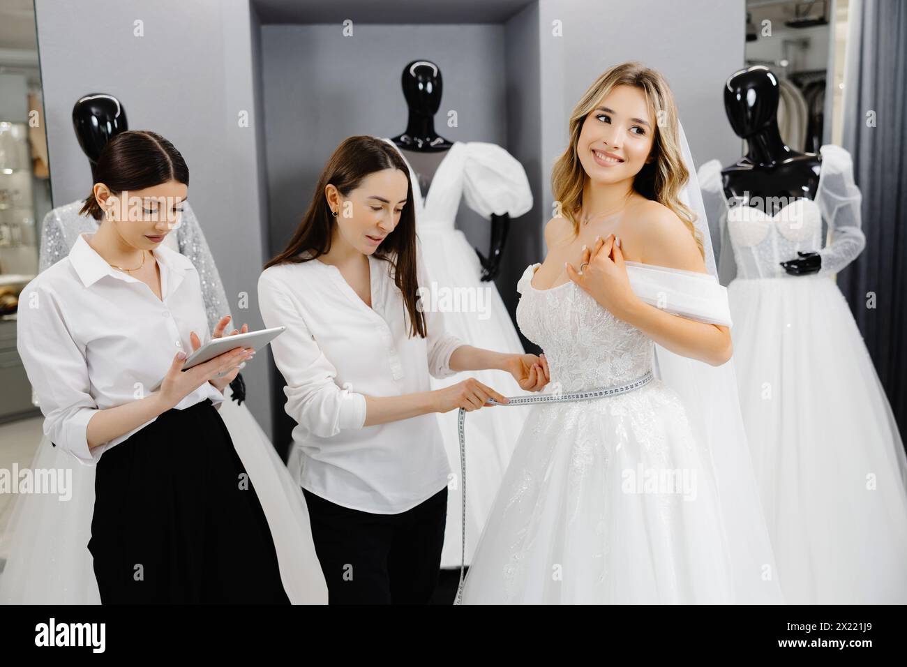 The bride-to-be chooses a dress for the wedding. A dressmaker's ...