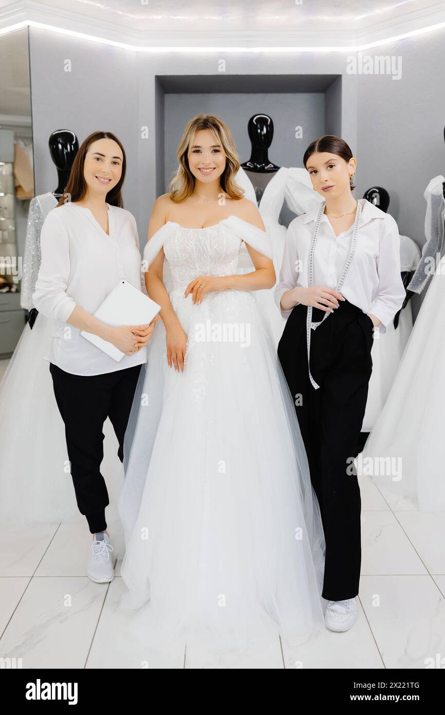 The bride-to-be chooses a dress for the wedding. A dressmaker's ...