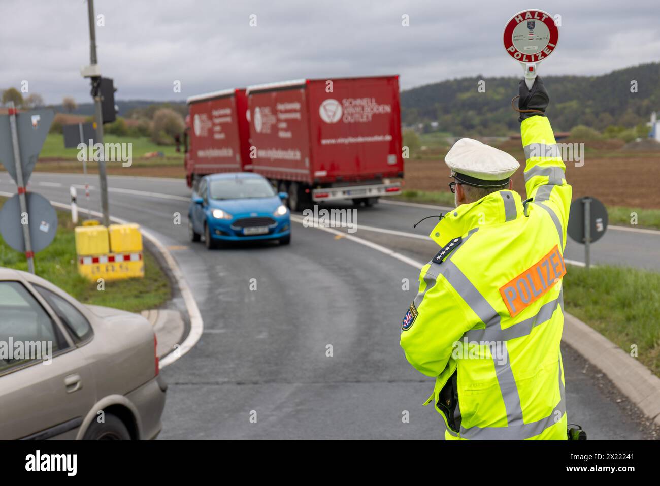19 April 2024, Hesse, Lahntal-Goßfelden: A police officer waves a ...