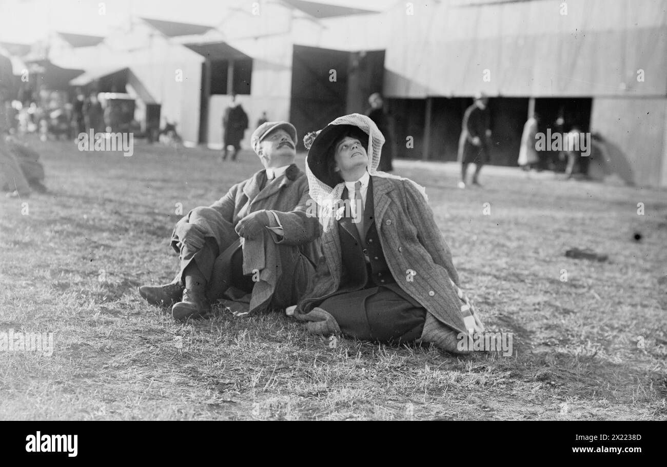 Mrs. Payne Whitney with unidentified gentleman seated on flying field ...