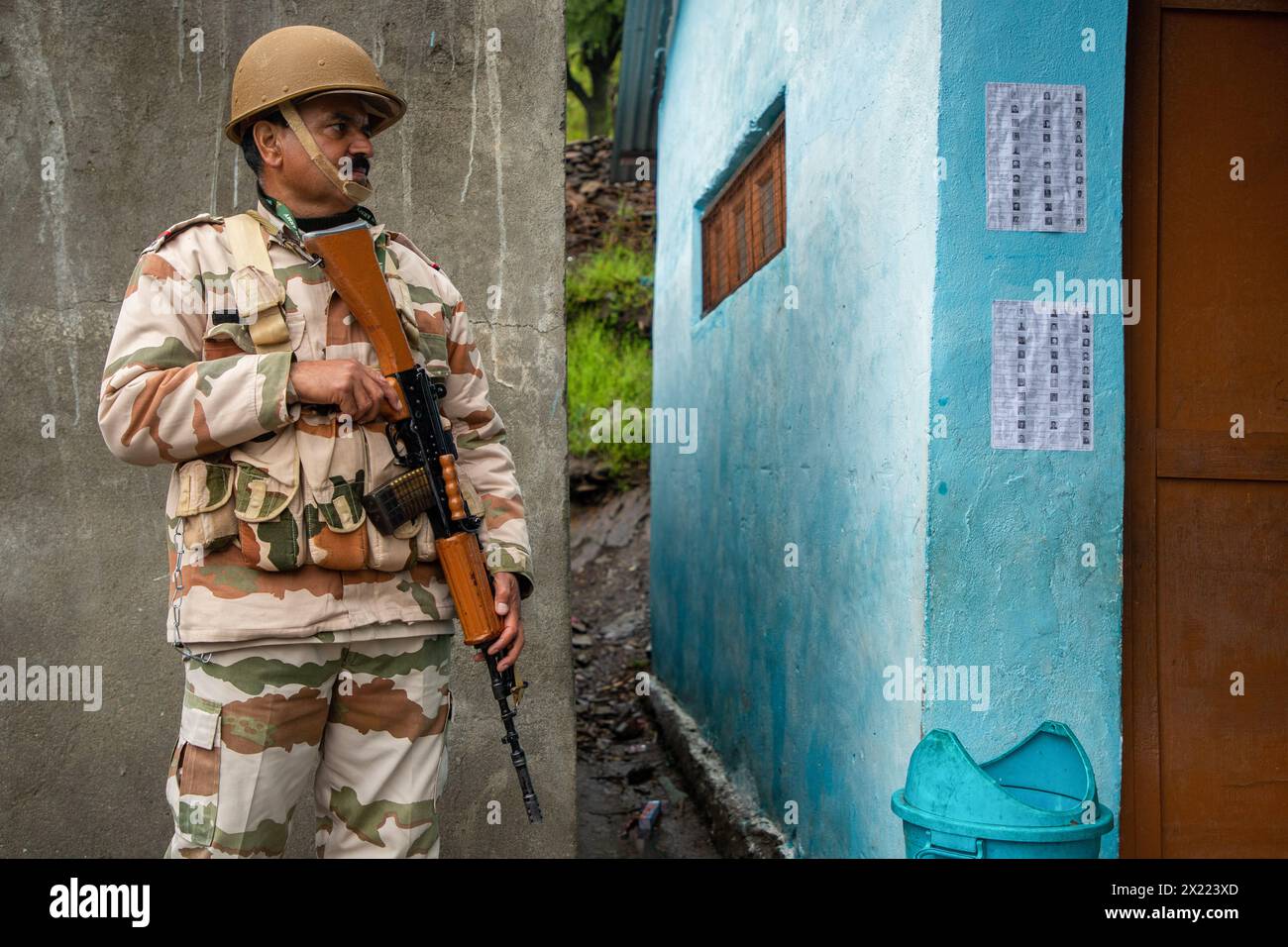 An Indian paramilitary soldier stands on guard outside a polling ...