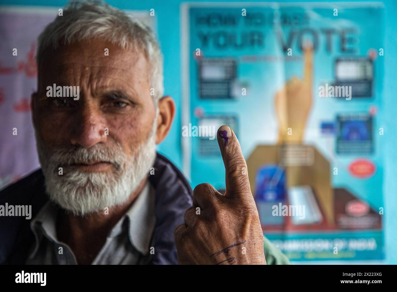 A man shows an ink-marked finger after casting his vote outside a ...