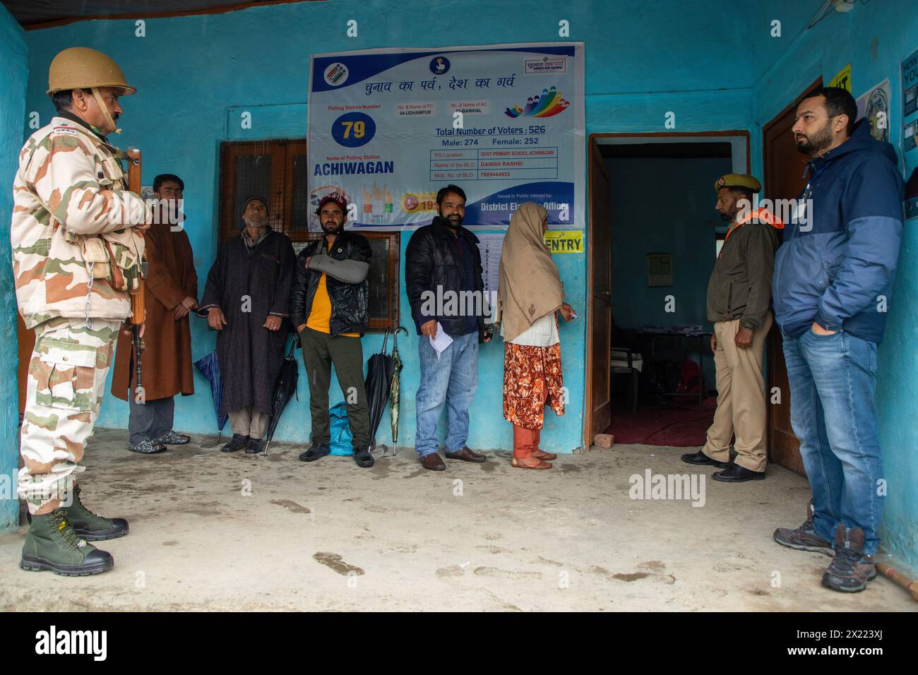 An Indian paramilitary soldier stands on guard as people wait in a ...