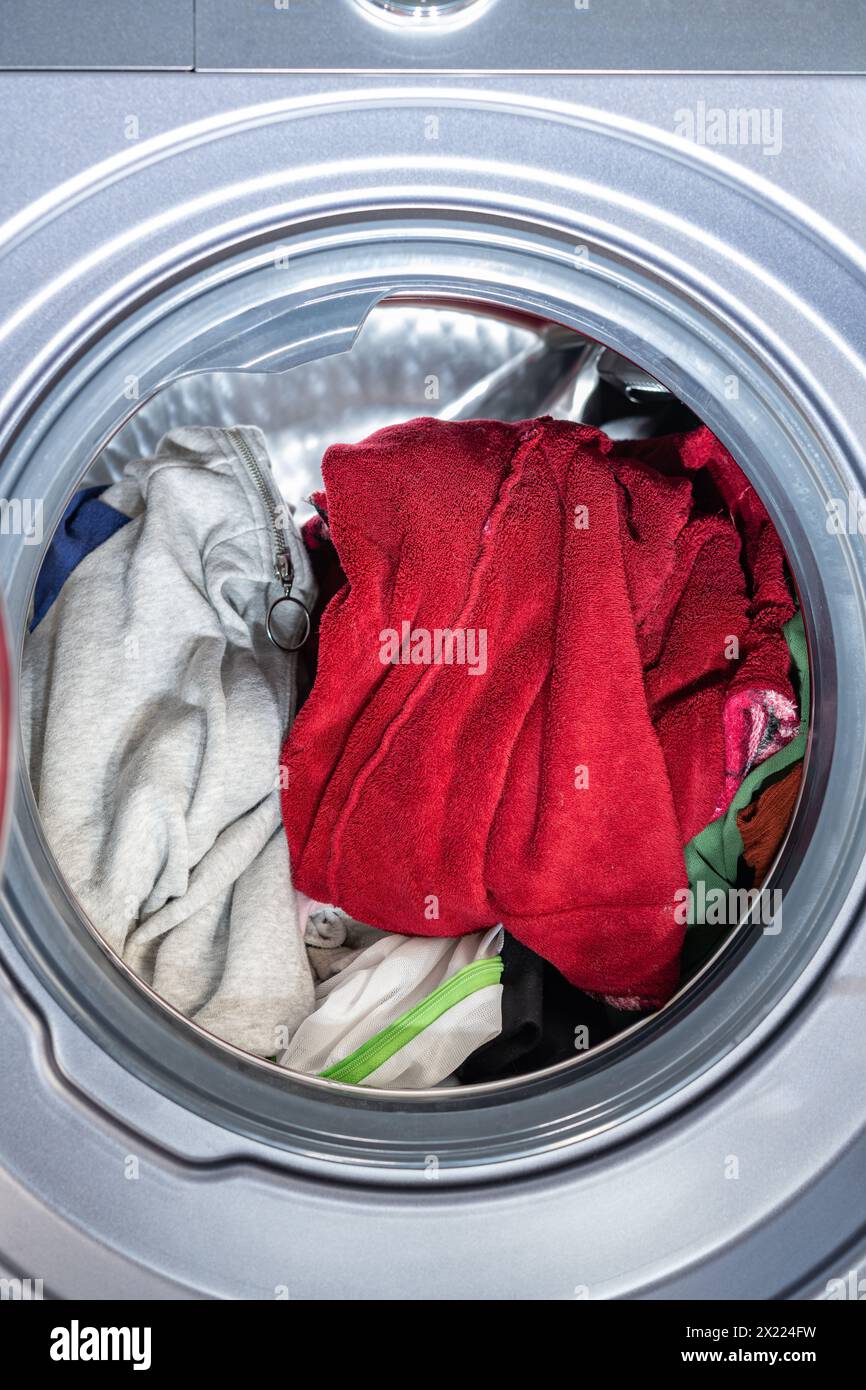 front-loading washing machine filled with clothes and about to start at ...
